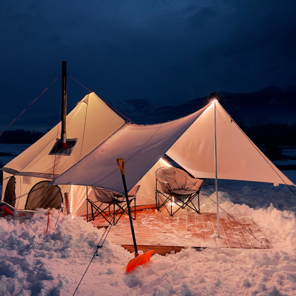 avalon bell tent set up in the snow with lights glowing inside and a ...